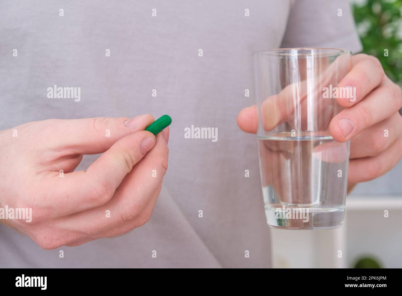 Caucasian man taking a pill and drinking a glass of water. Young man ...