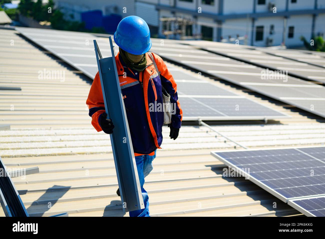 Male technician worker installing solar panels on rooftop of industrial ...