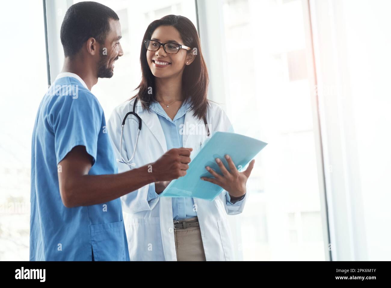 Double the knowledge between them. two young doctors discussing the ...
