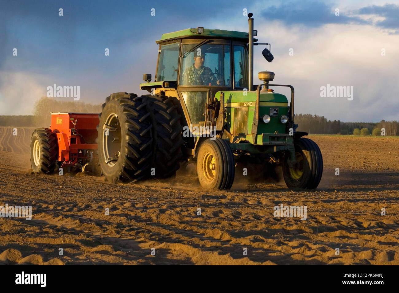 John Deere 2140 tractor pulling Tume seed drill, drilling arable field ...