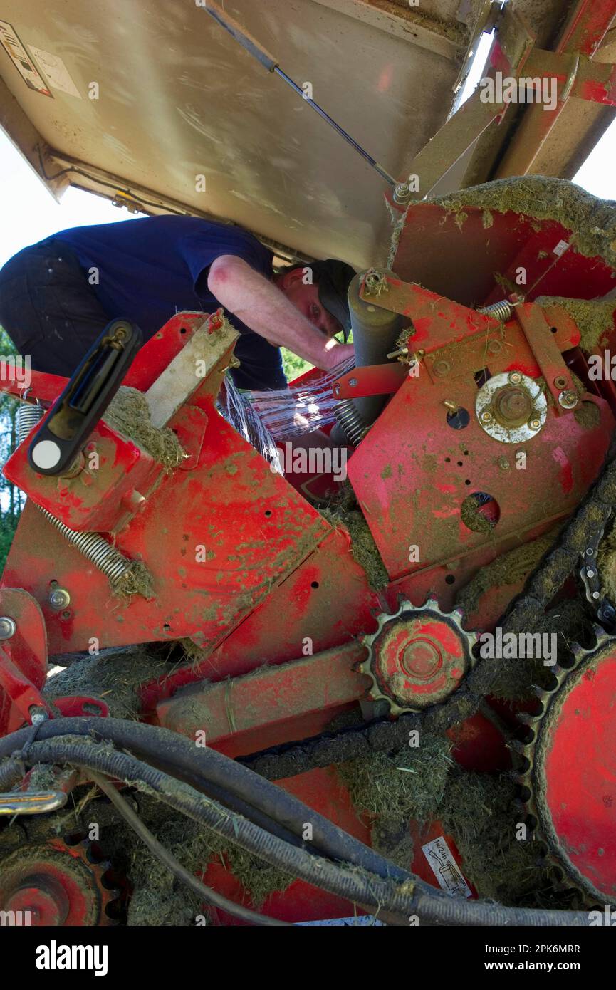 Farmer working on round baler, Sweden Stock Photo - Alamy