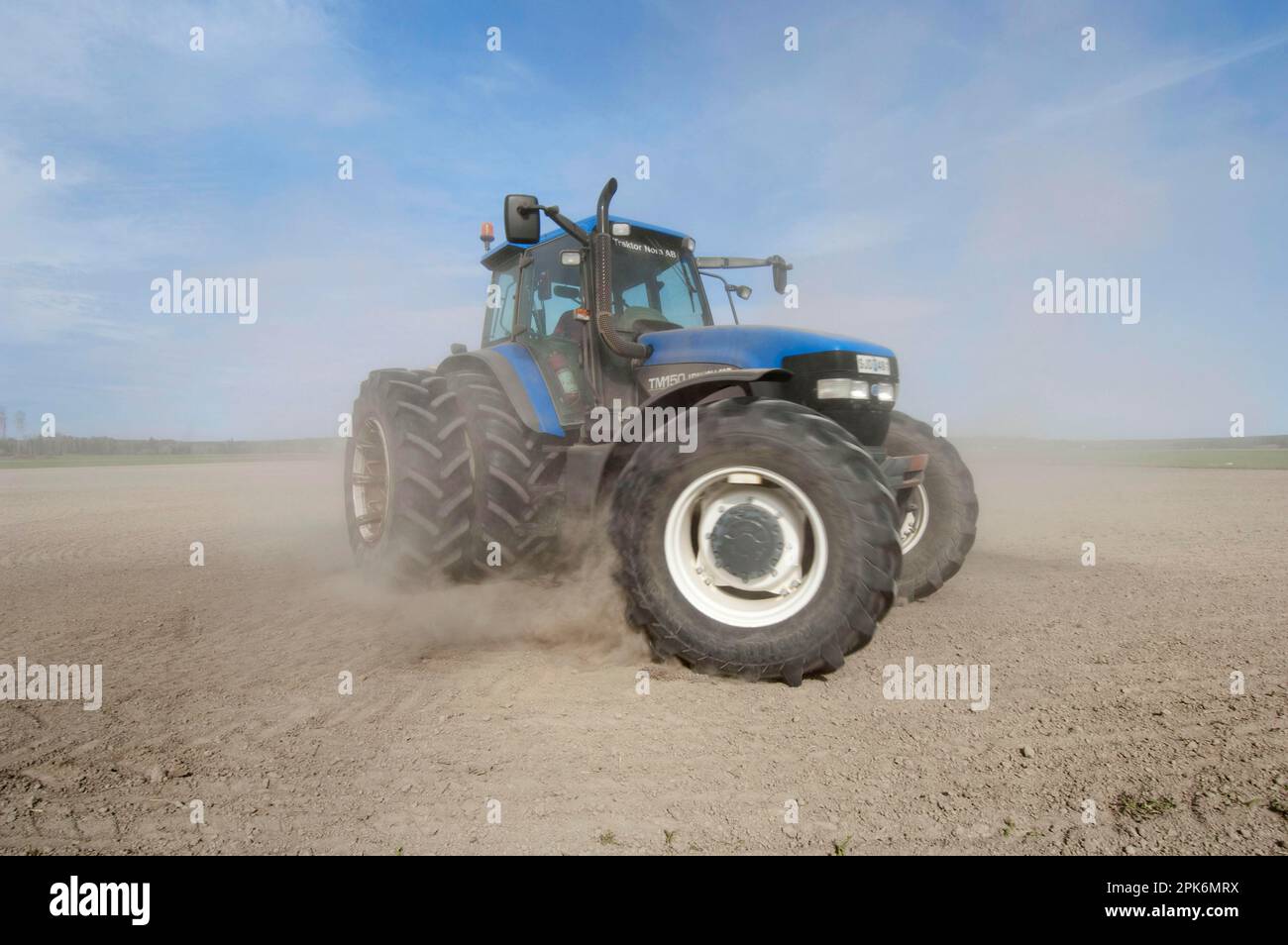 New Holland TM150 tractor, sowing in field with windblown dust, Sweden ...