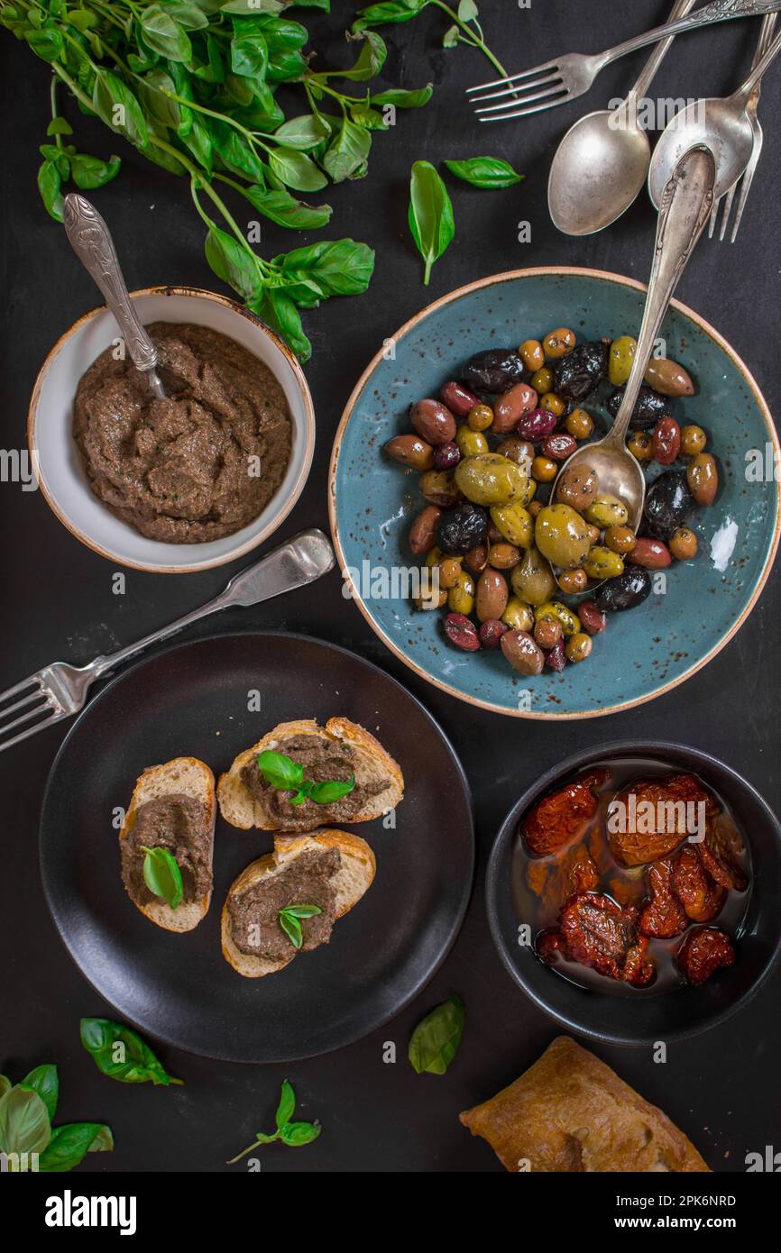 Table served with bread, tapenade, assorted olives, dried tomatoes in ...