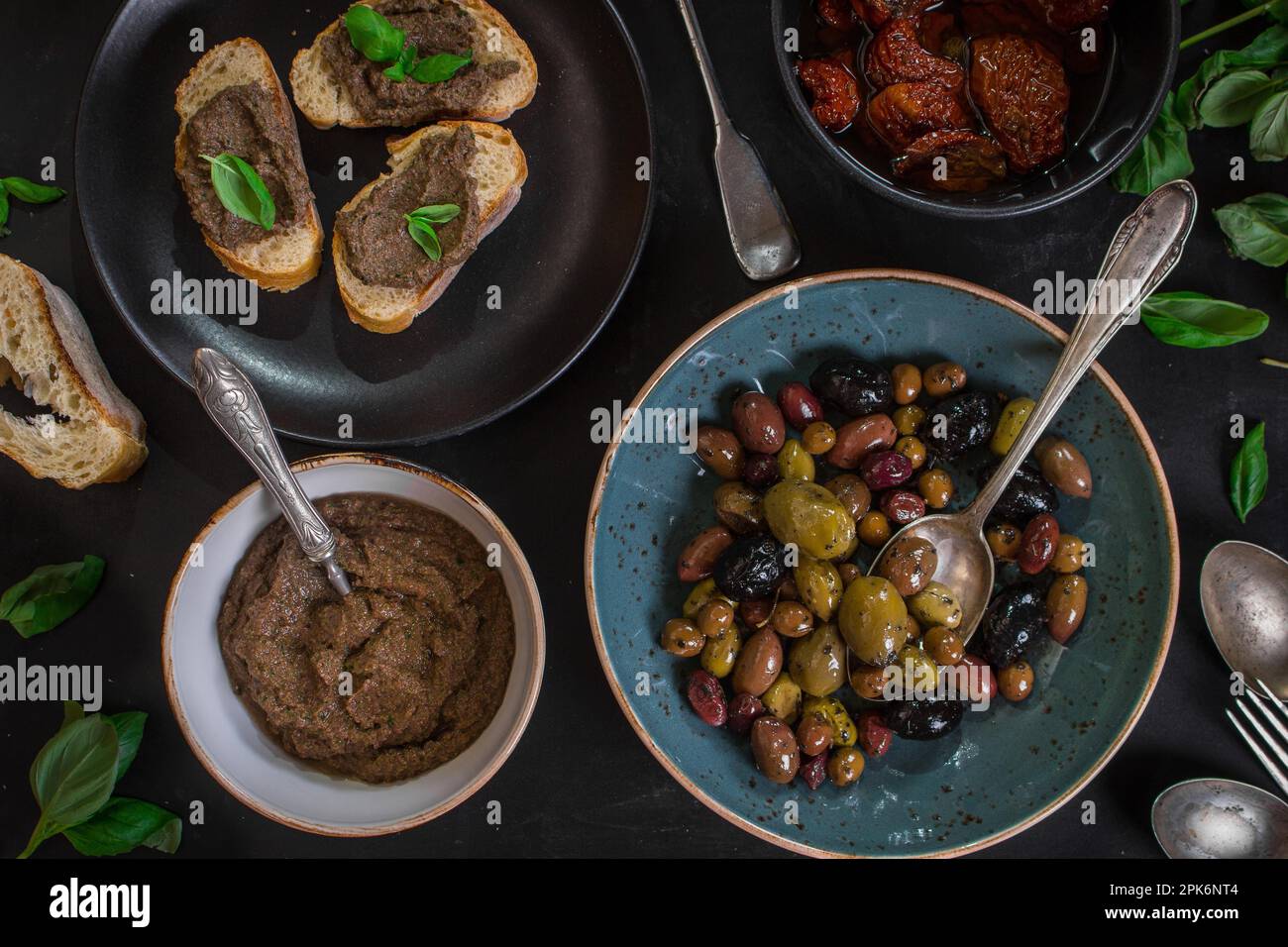 Table served with bread, tapenade, assorted olives, dried tomatoes in ...