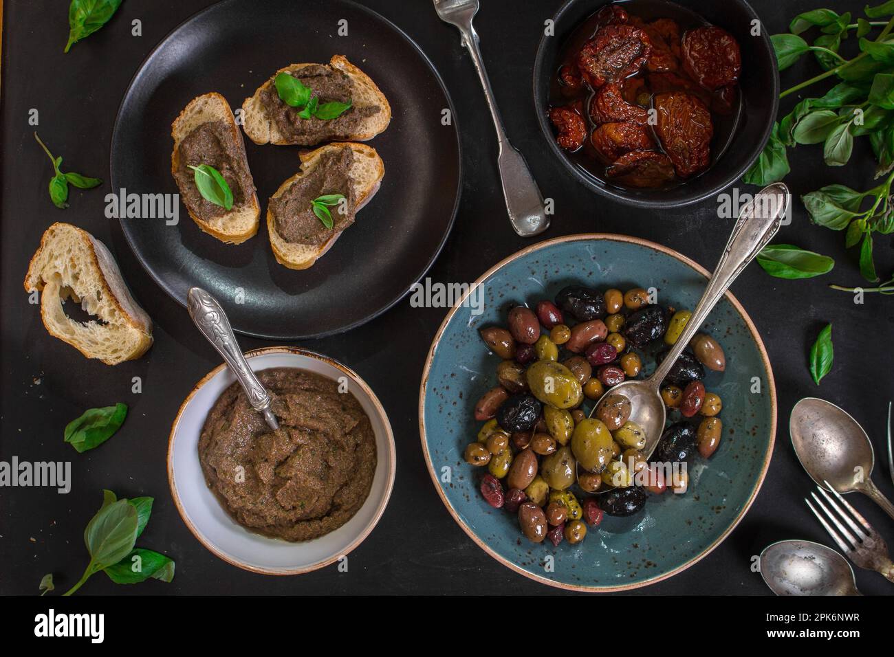 Table served with bread, tapenade, assorted olives, dried tomatoes in ...