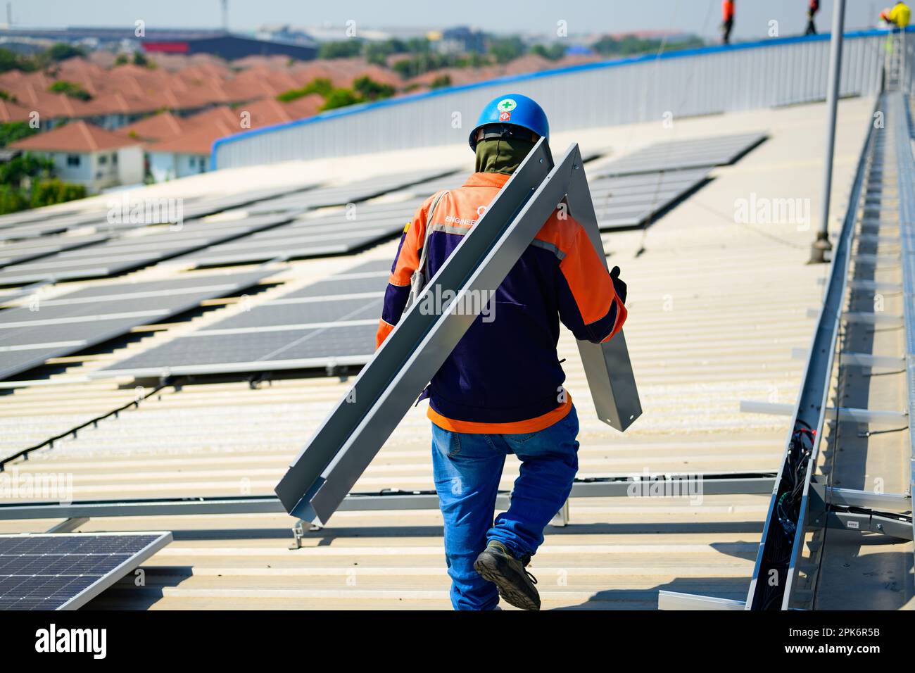 Male technician worker installing solar panels on rooftop of industrial ...