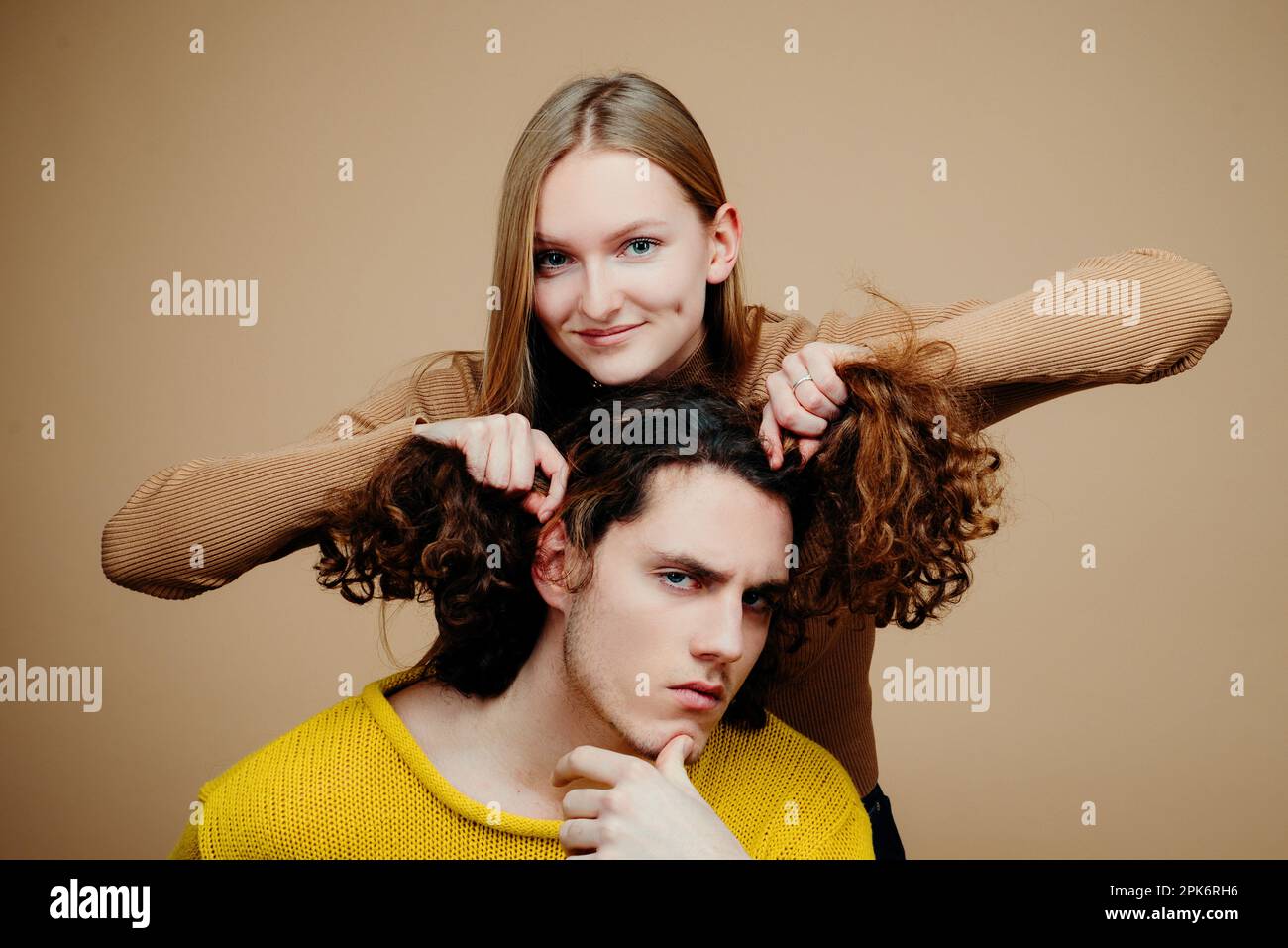 Happy couple in love studio photo. Handsome man with long wavy hair and ...