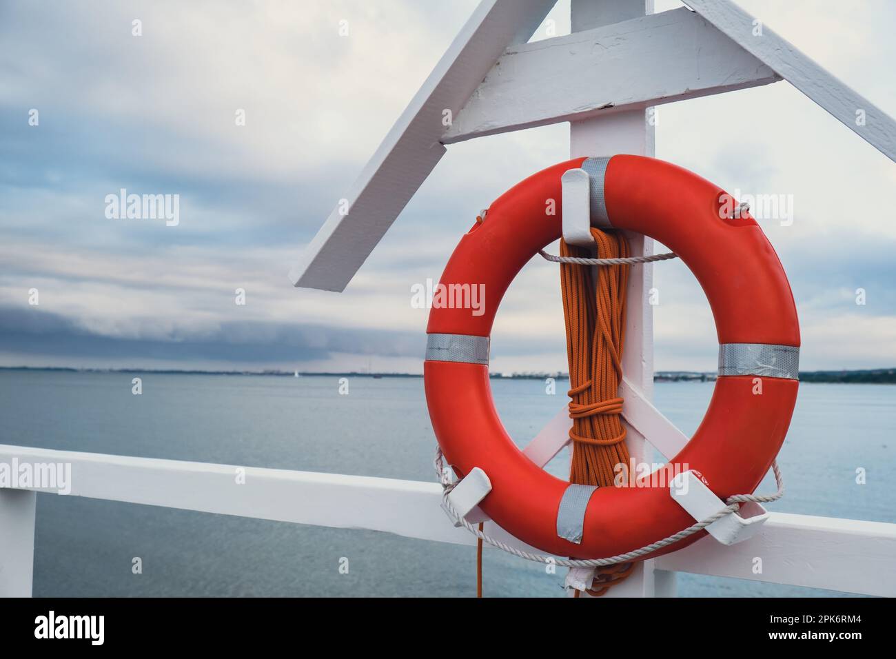 Orange lifebuoy on the pier beach by sea. Safety equipment for rescuing ...