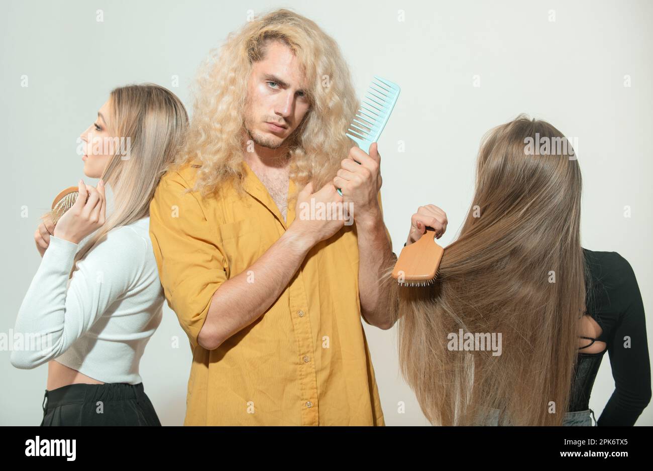 Group of young women and man combing hair. People combing hair, girls ...