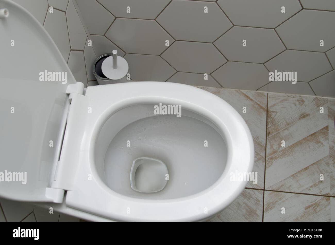 Close-up of a toilet in a hexagon tiled washroom Stock Photo - Alamy