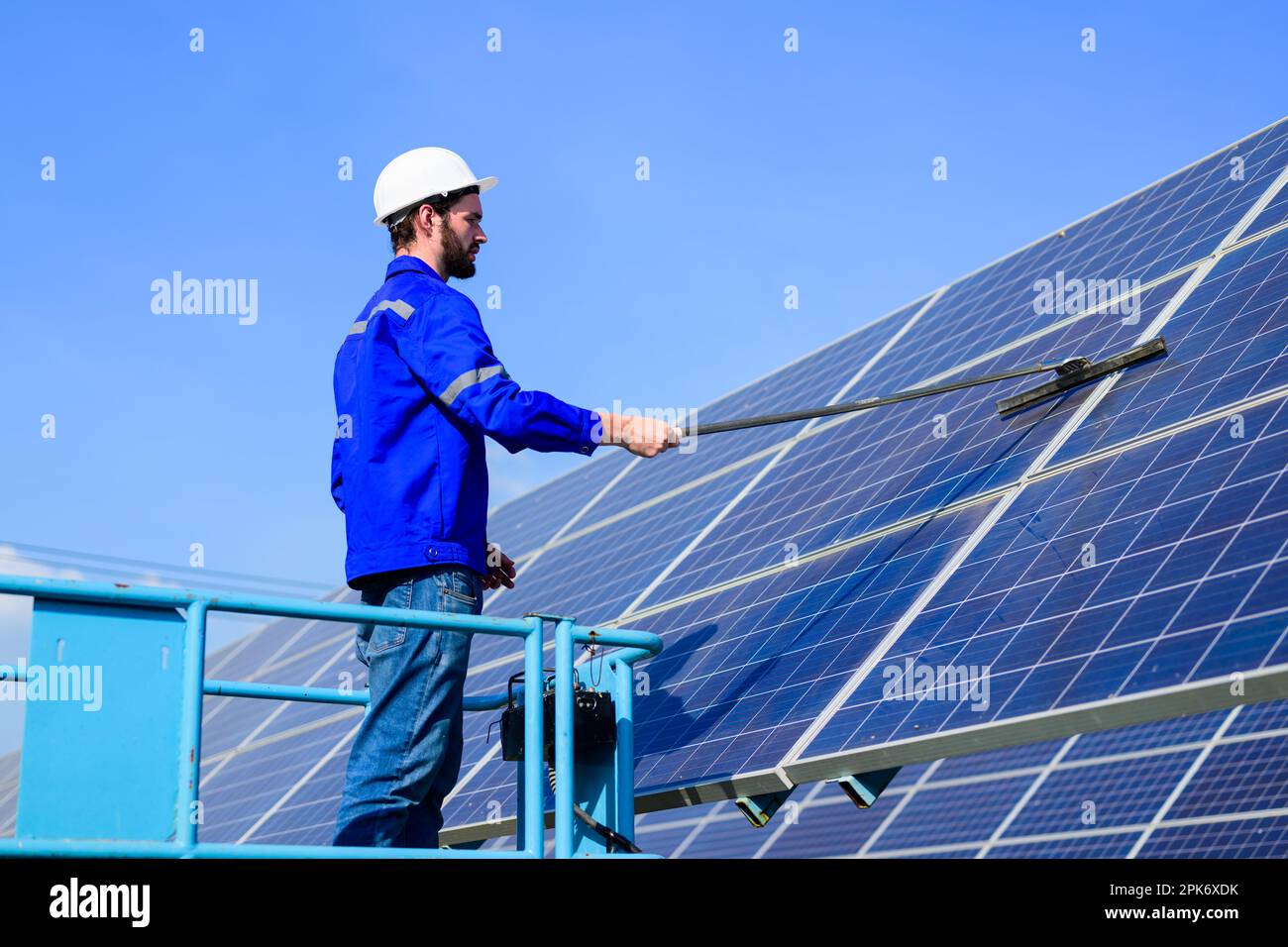 Worker cleaning solar panel at solar cell farm Stock Photo - Alamy