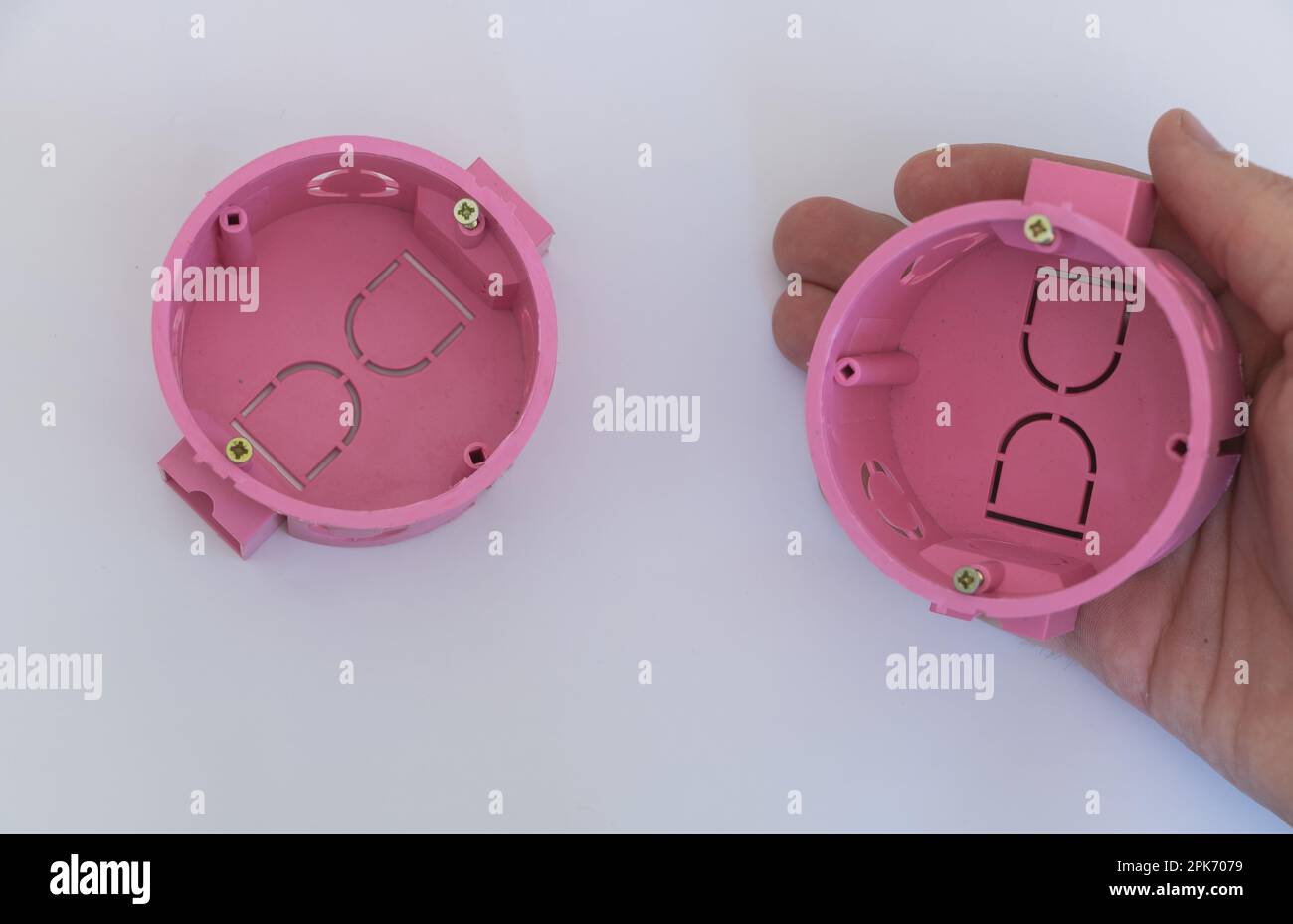 Close-up of two pink plastic socket on a white background and one in ...