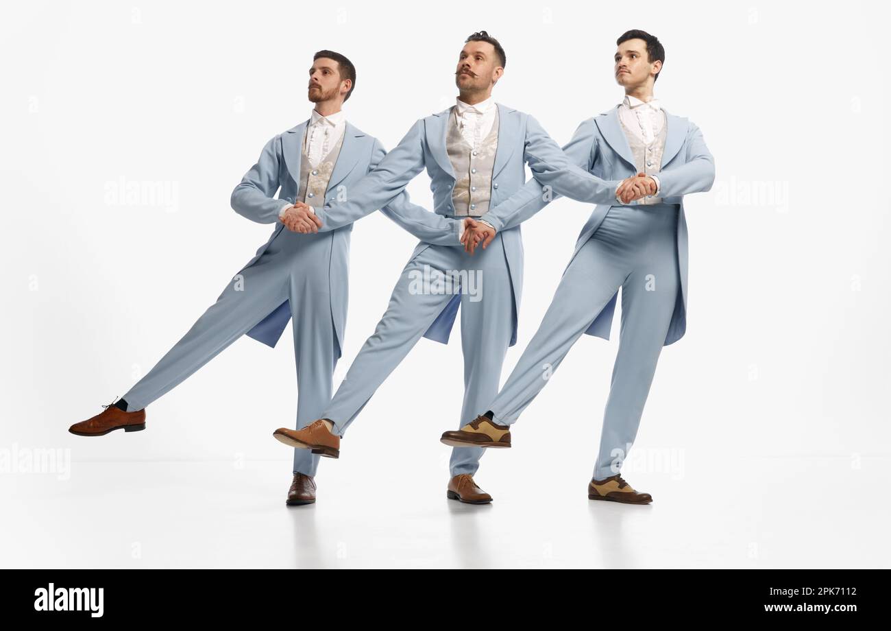 Portrait with three men wearing elegant clothes standing in a row and ...