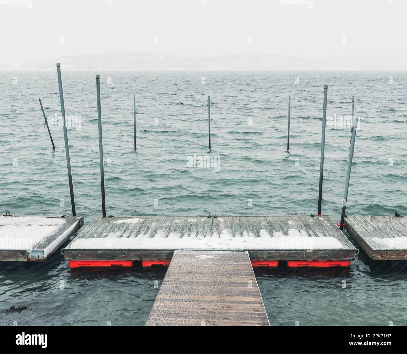 A lone jetty stretches out into a winter sea. No people stir in the off ...