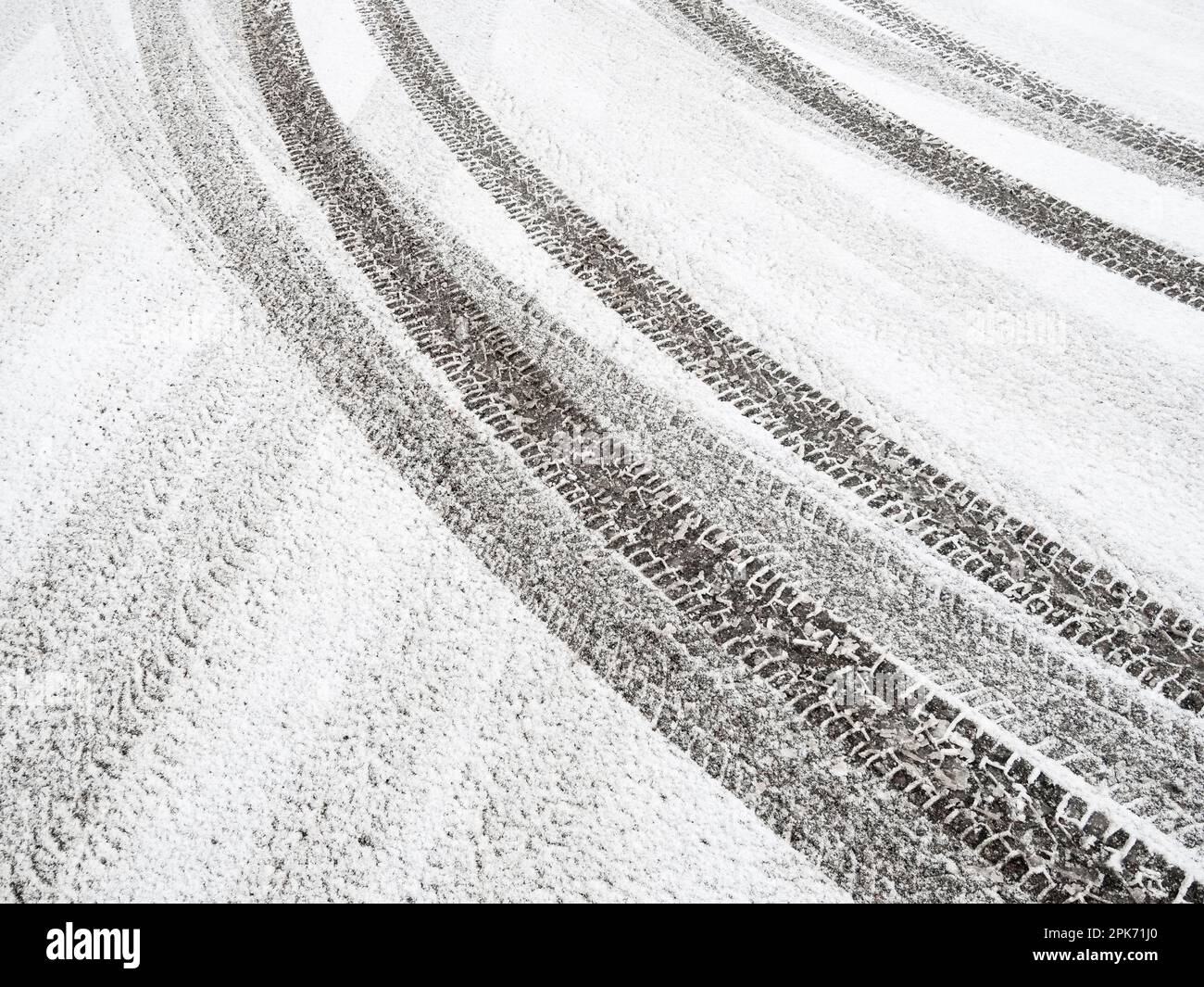 Fresh, untouched snow blankets the wintery street. Tire marks create a ...