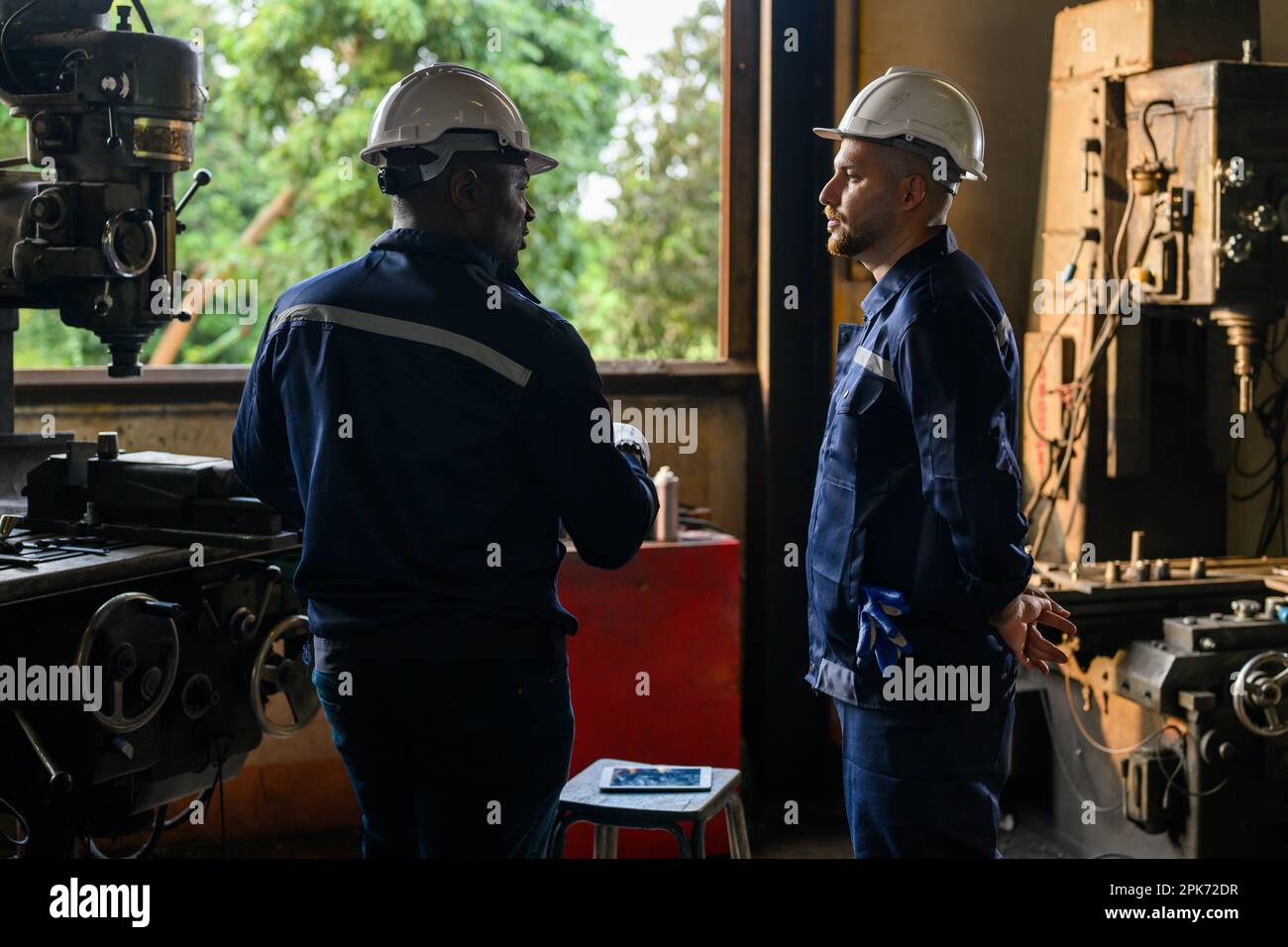 Two industrial engineers team with safety uniform talking Stock Photo ...