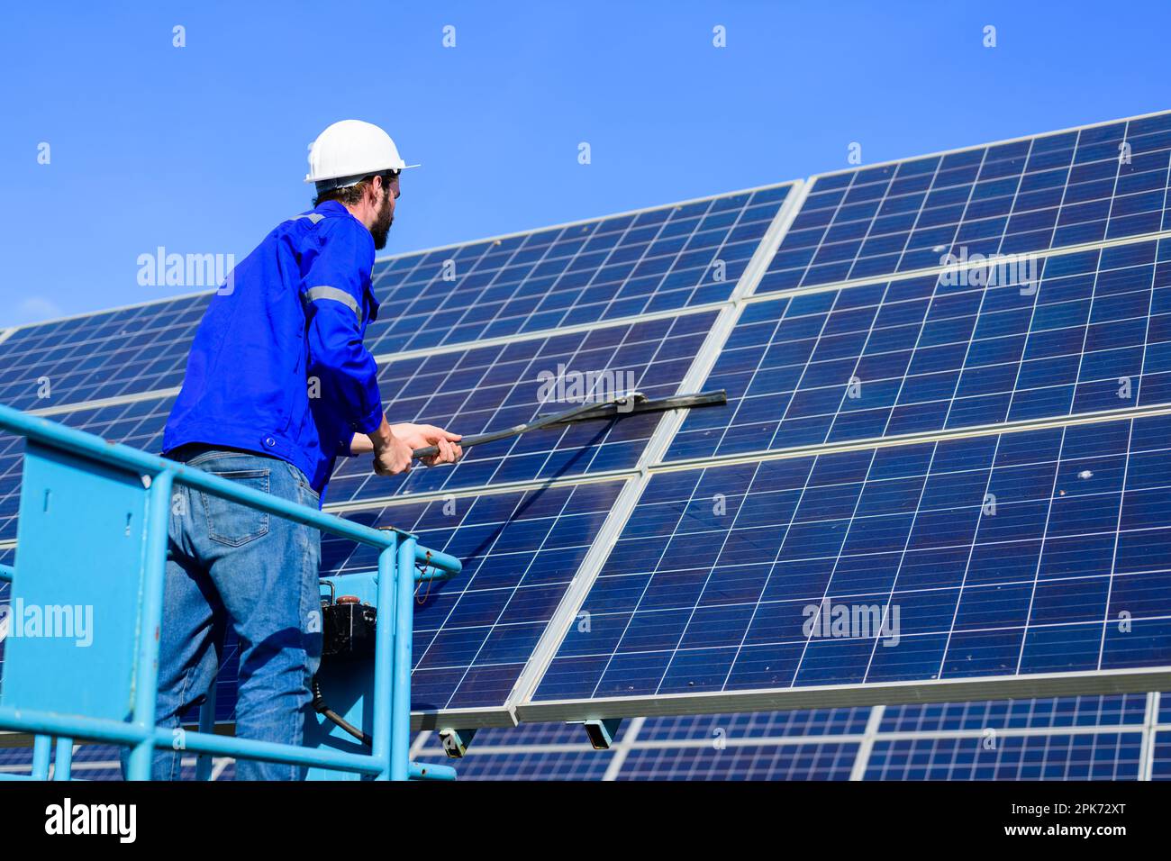 Worker cleaning solar panel at solar cell farm Stock Photo - Alamy