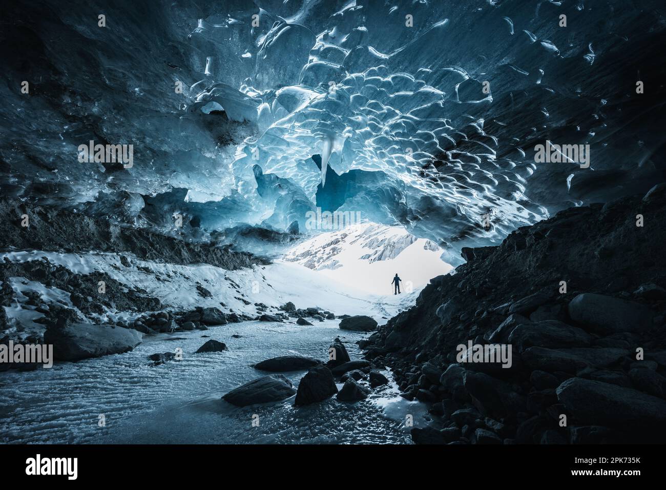 Hiker silhouette exploring an ice cave in the Langgletscher in ...