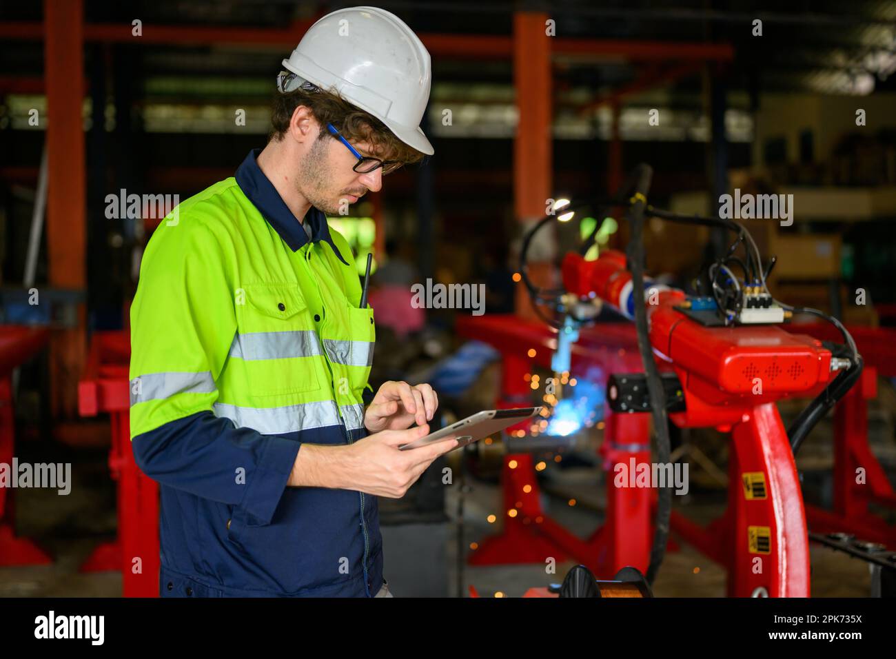 Young industrial engineer holding tablet checking and controlling ...