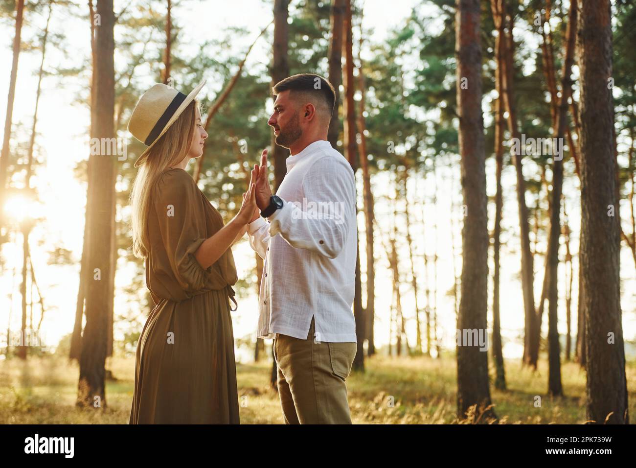Embracing each other. Happy couple is outdoors in the forest at daytime ...