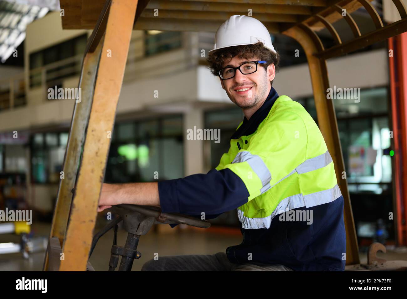 Portrait of happy male mechanical engineer in white hard hat and safety ...