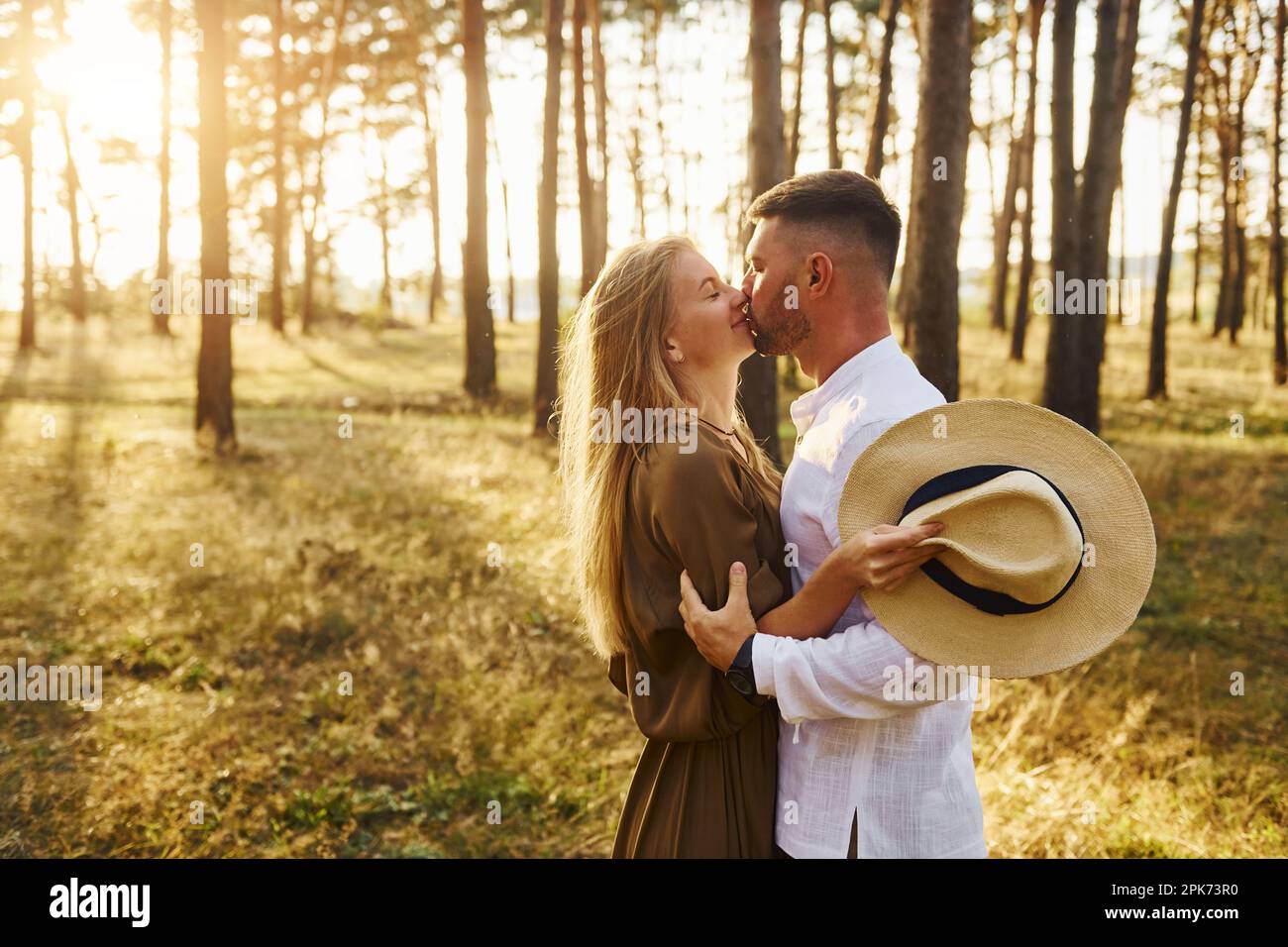 Embracing and kissing. Happy couple is outdoors in the forest at ...