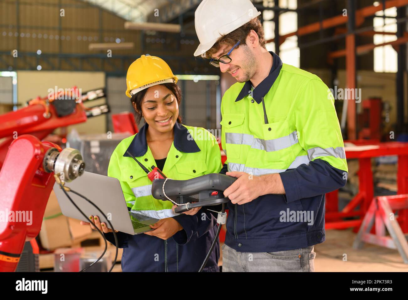 Happy male and female mechanical engineers in hard hat and safety ...