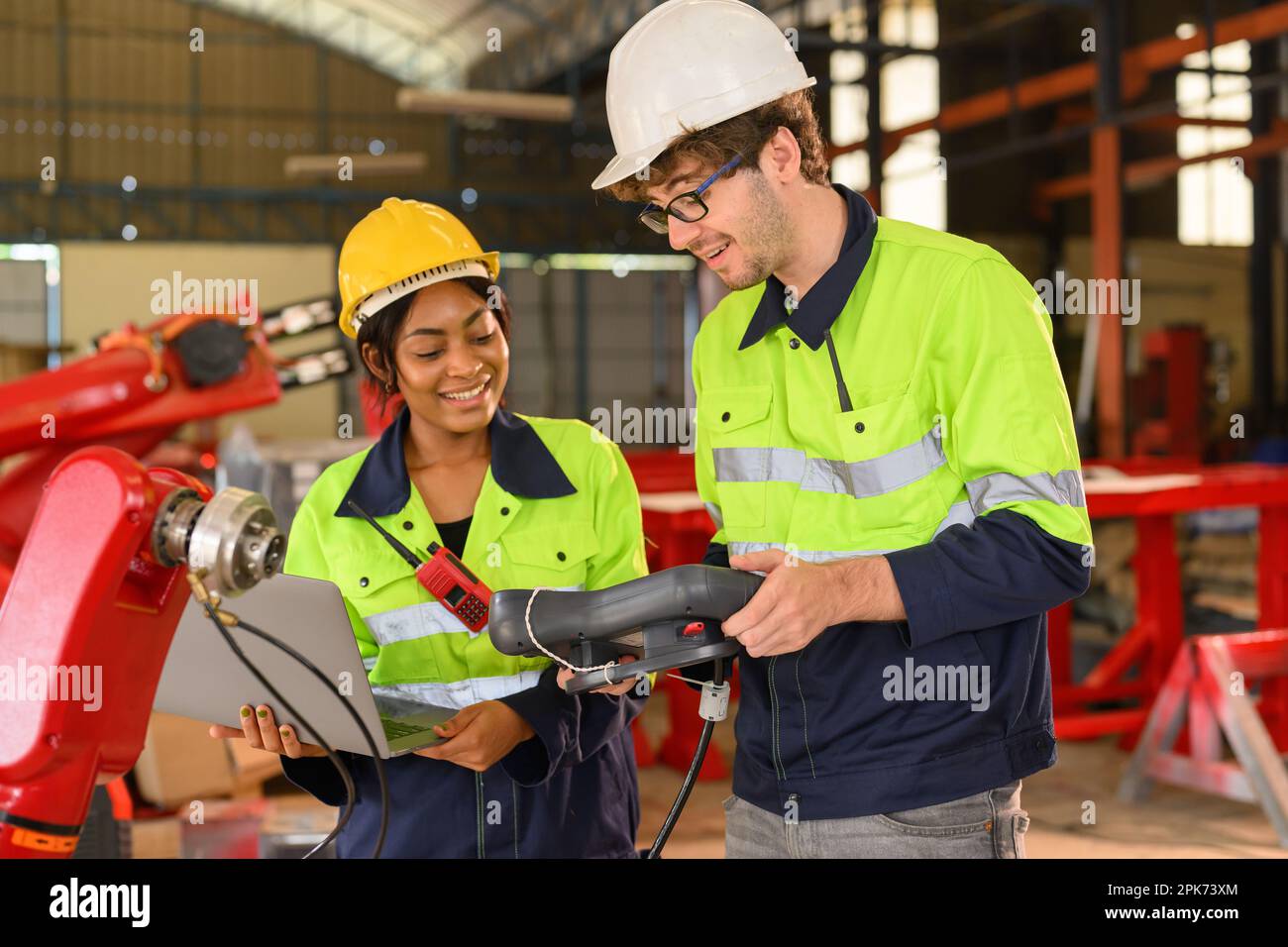 Happy male and female mechanical engineers in hard hat and safety ...