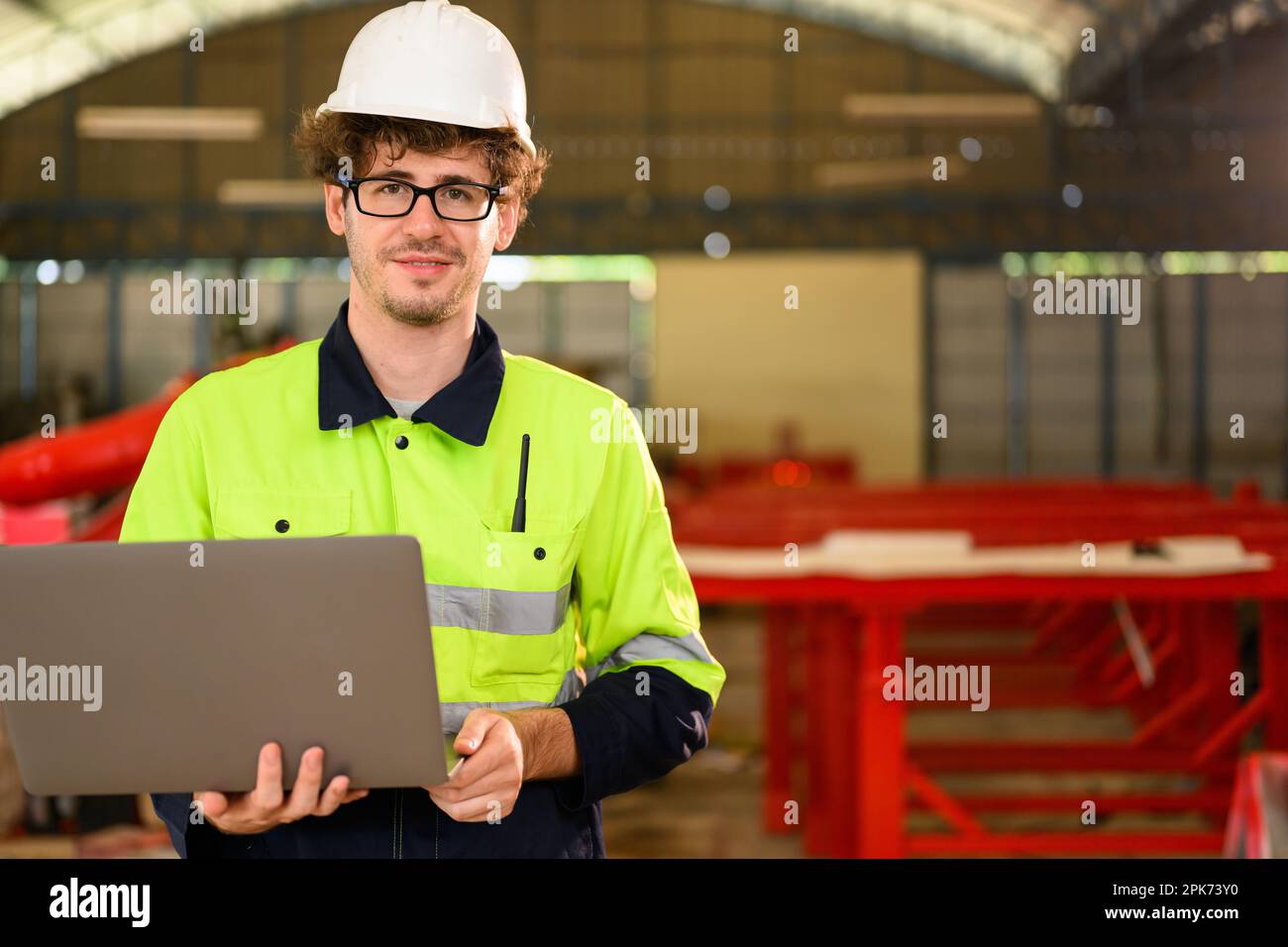 Portrait of happy male mechanical engineer in white hard hat and safety ...