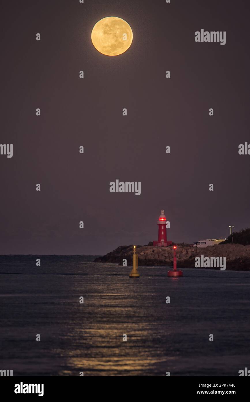 Full moon setting behind the North Mole lighthouse at Fremantle Port ...