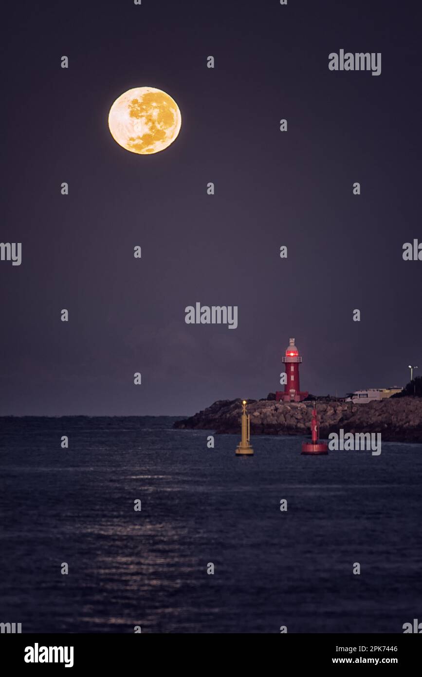 Full moon setting behind the North Mole lighthouse at Fremantle Port ...