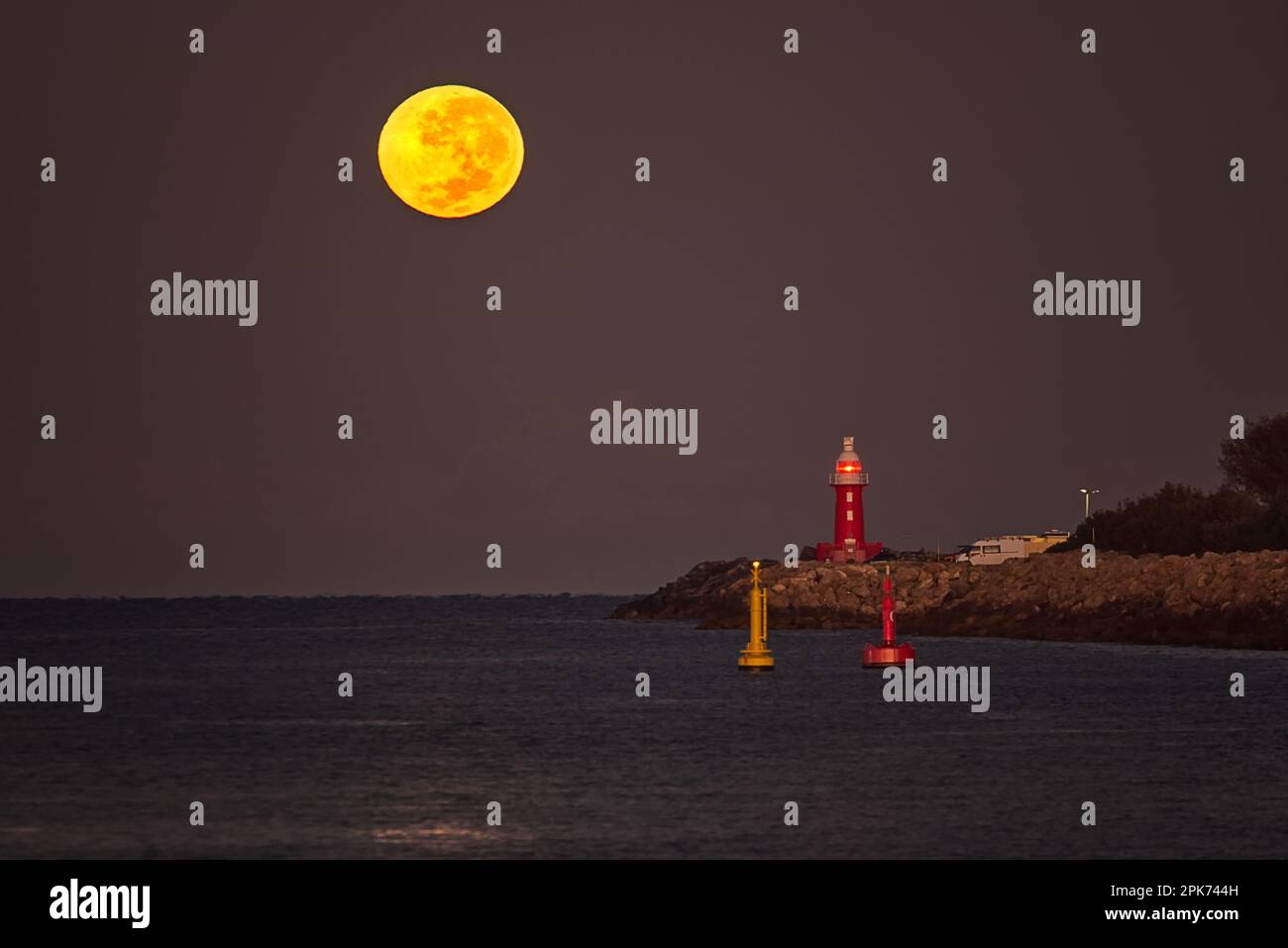 Full moon setting behind the North Mole lighthouse at Fremantle Port ...