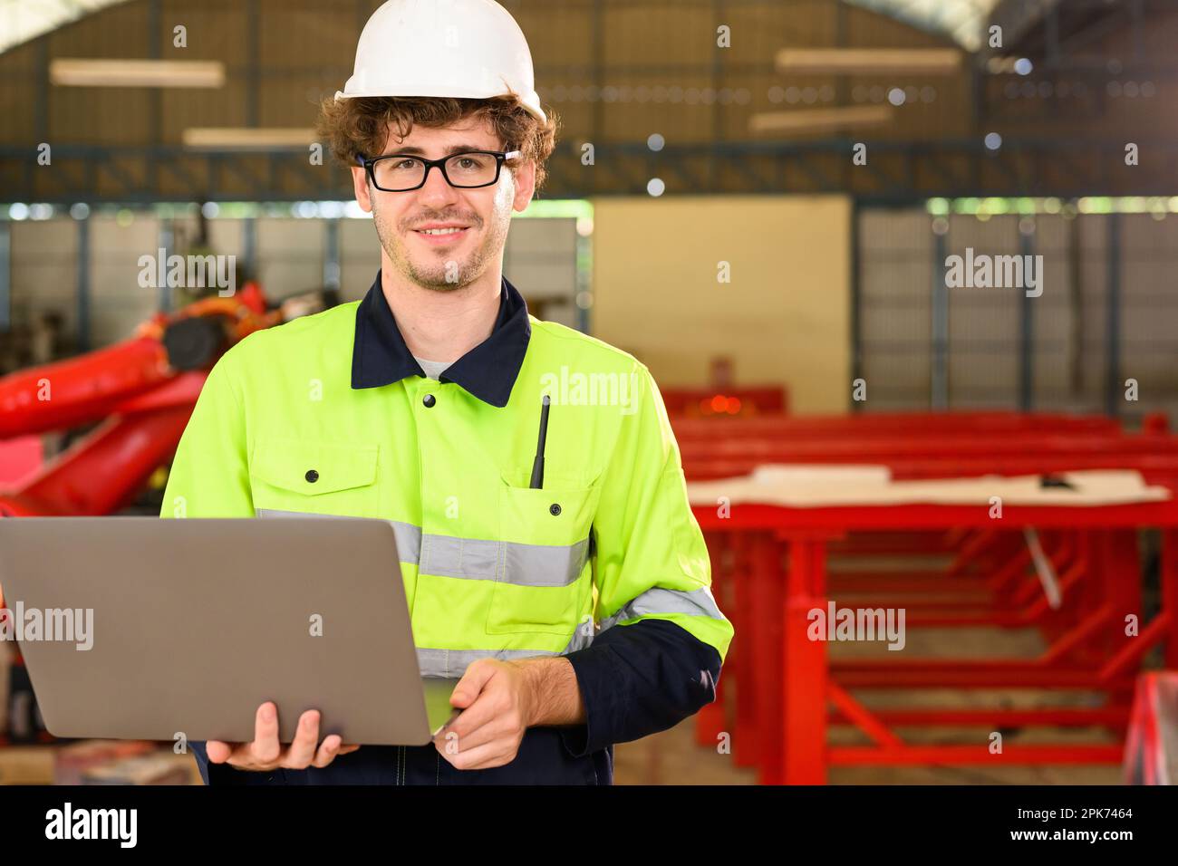 Portrait of happy male mechanical engineer in white hard hat and safety ...
