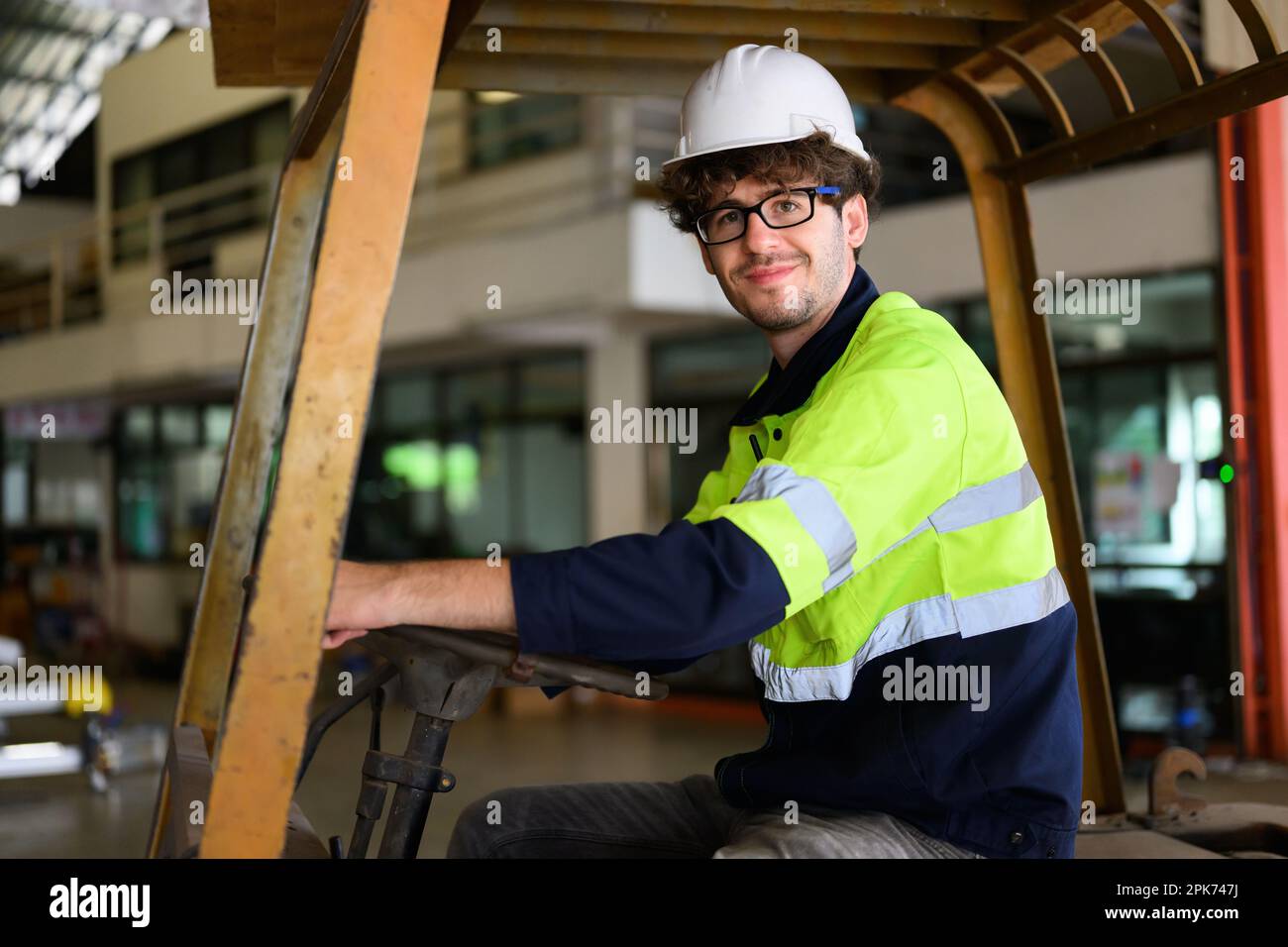 Portrait of happy male mechanical engineer in white hard hat and safety ...