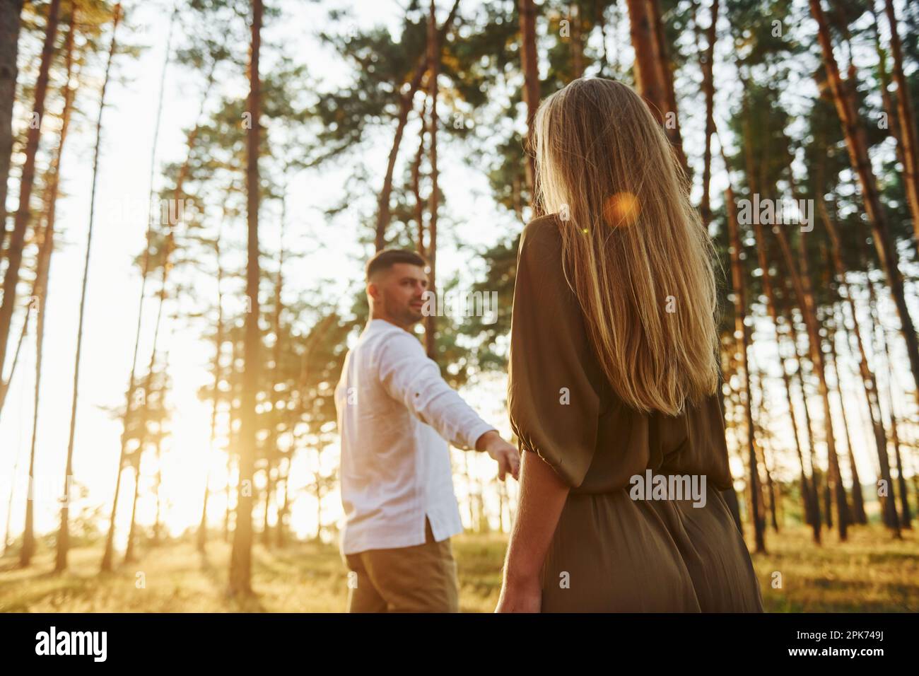 Cheerful people. Happy couple is outdoors in the forest at daytime ...