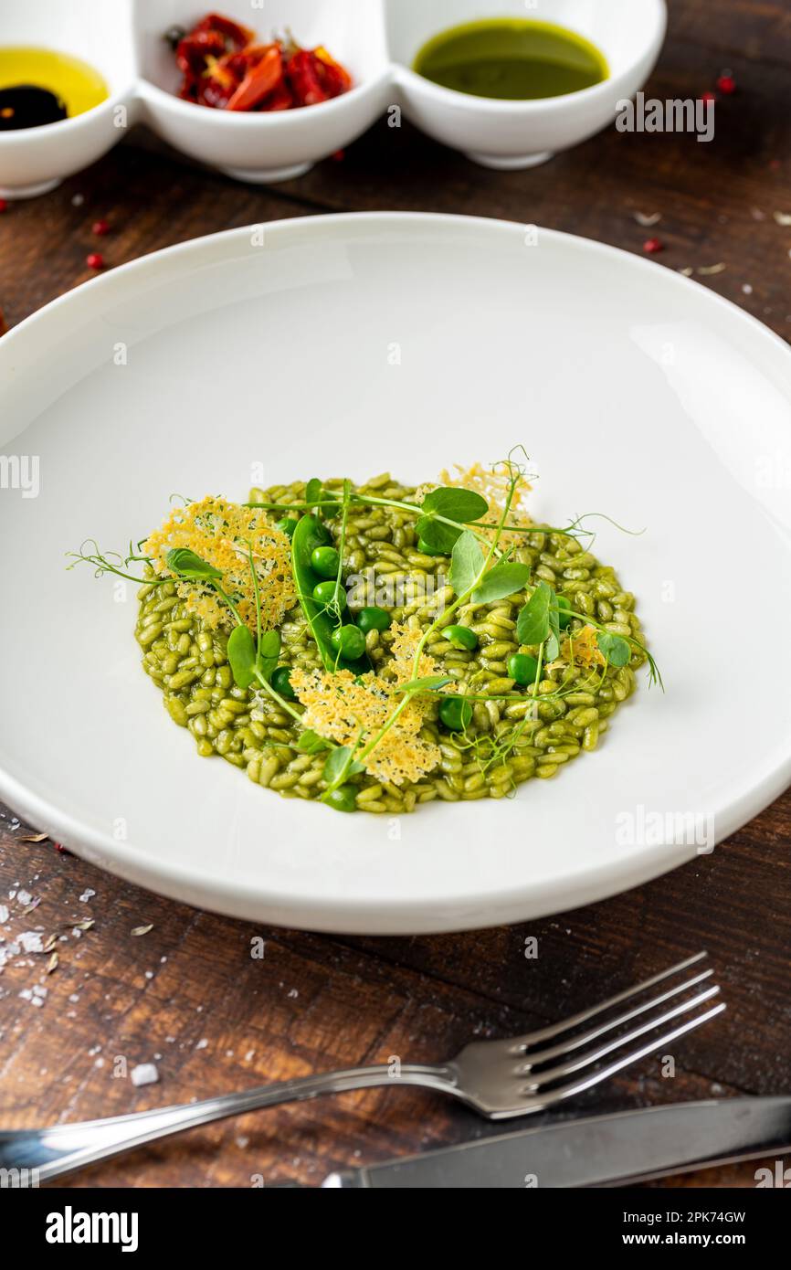 Pea risotto on a white porcelain plate in a fine dining restaurant ...