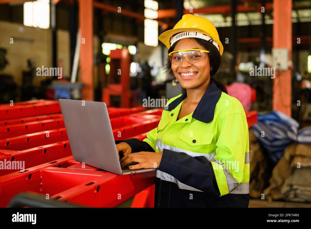 Portrait of female mechanical engineer in yellow hard hat and safety ...