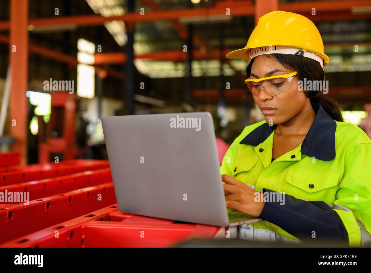 Portrait of female mechanical engineer in yellow hard hat and safety ...