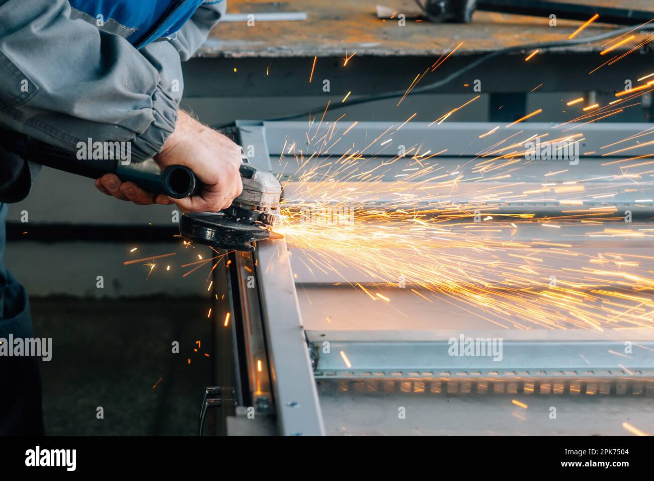 Hands of worker with close-up grinder during workflow. Man grinds ...