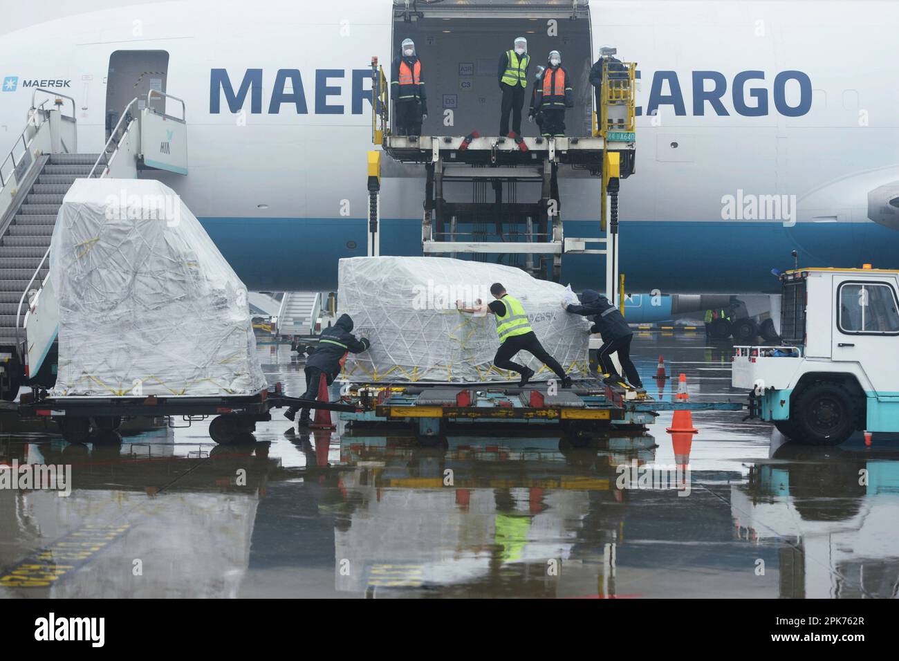 Workers load cargo onto a Boeing 767-300 cargo plane owned by the ...