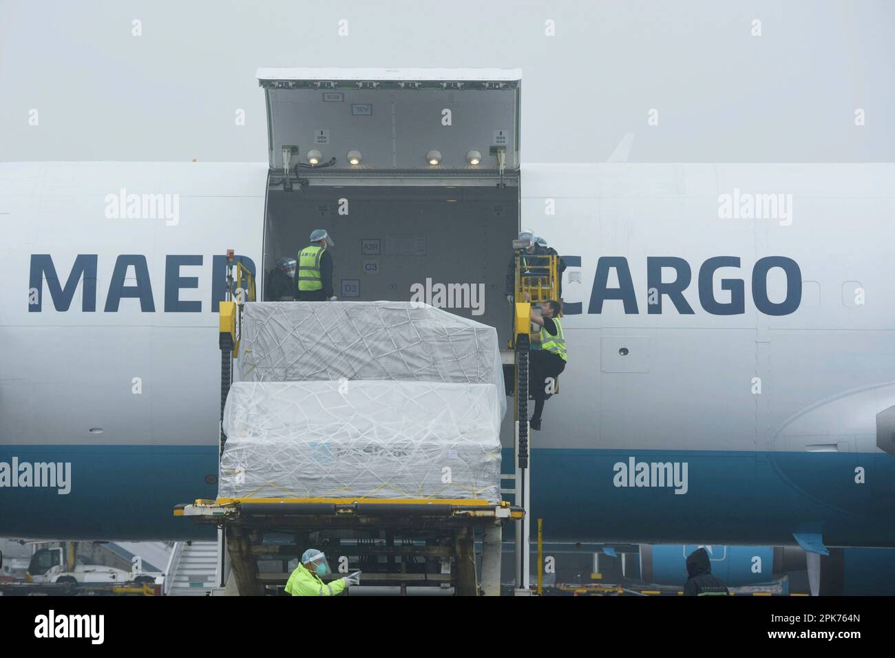 Workers load cargo onto a Boeing 767-300 cargo plane owned by the ...