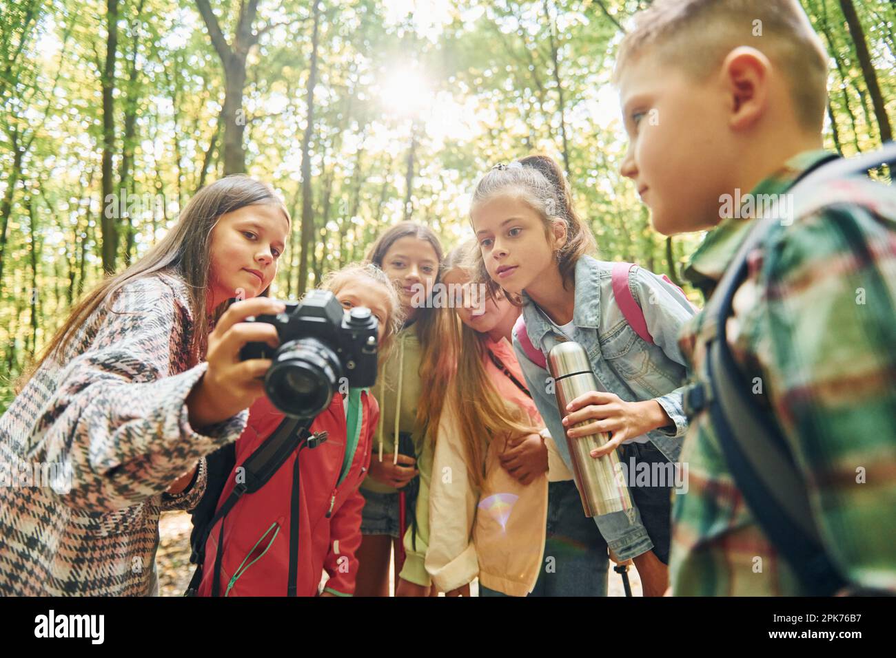Holding camera. Kids in green forest at summer daytime together Stock ...