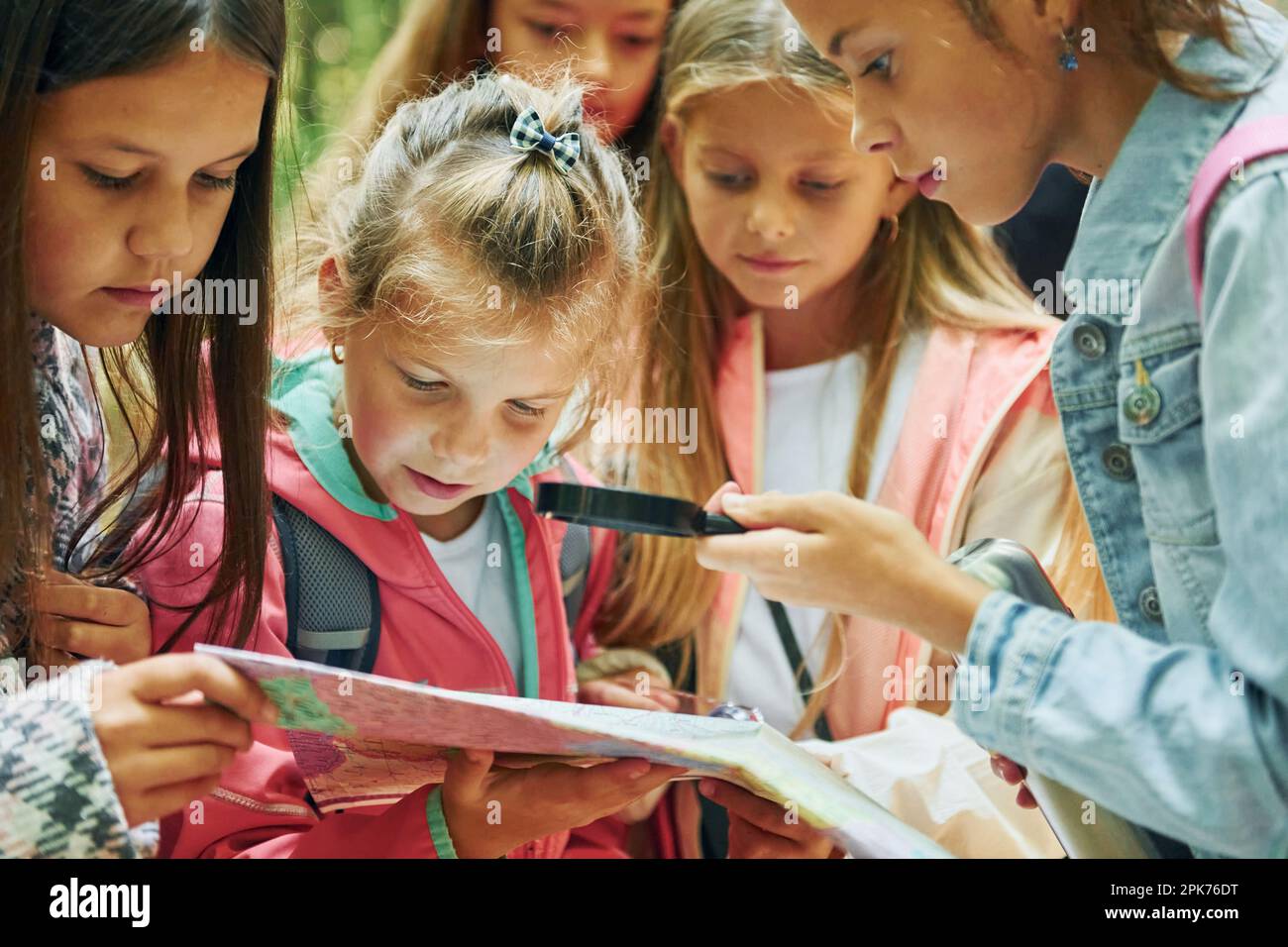 With map. Kids in green forest at summer daytime together Stock Photo ...