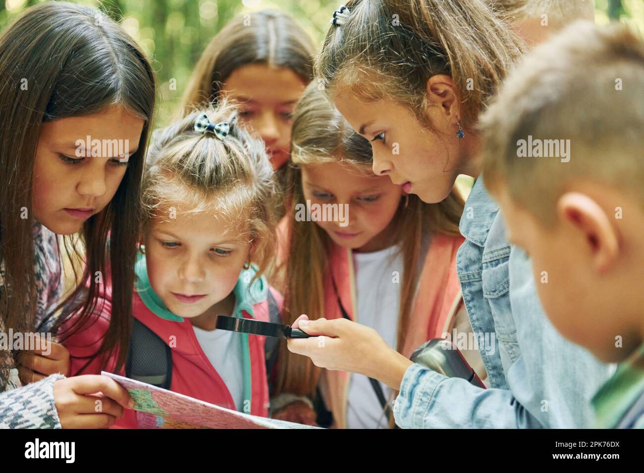 With map. Kids in green forest at summer daytime together Stock Photo ...
