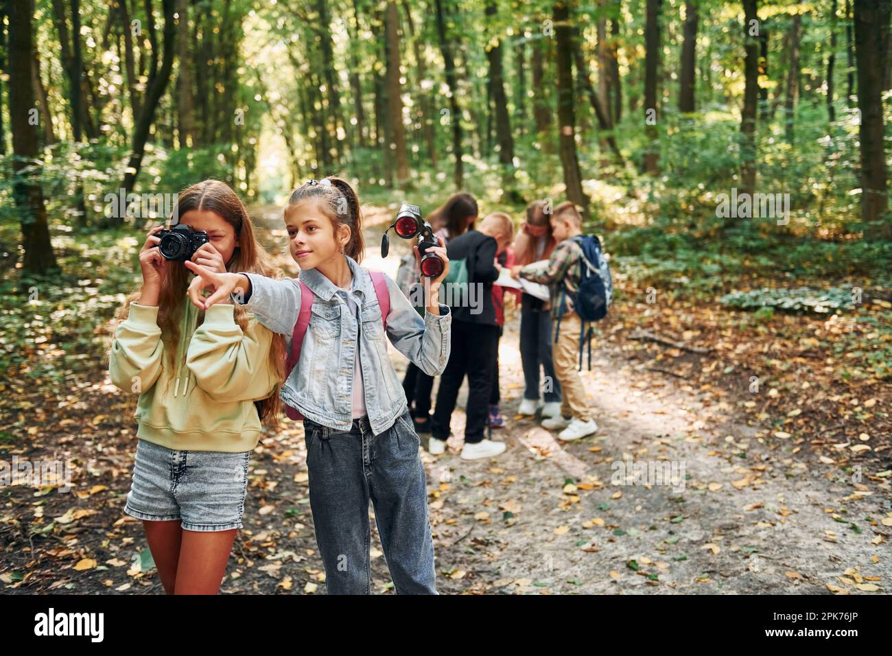 Looking for a path. Kids in green forest at summer daytime together ...