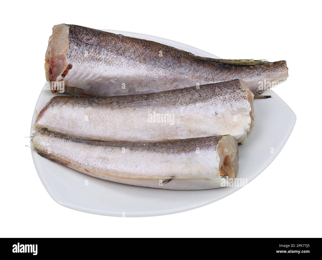 Defrosted raw hake lies on a triangular plate isolated on white Stock ...