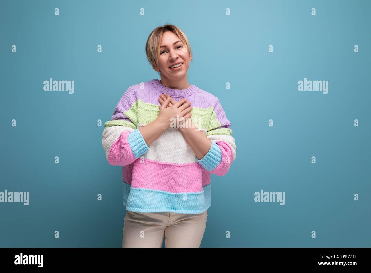 cute blond woman showing courtesy gesture on blue background Stock ...