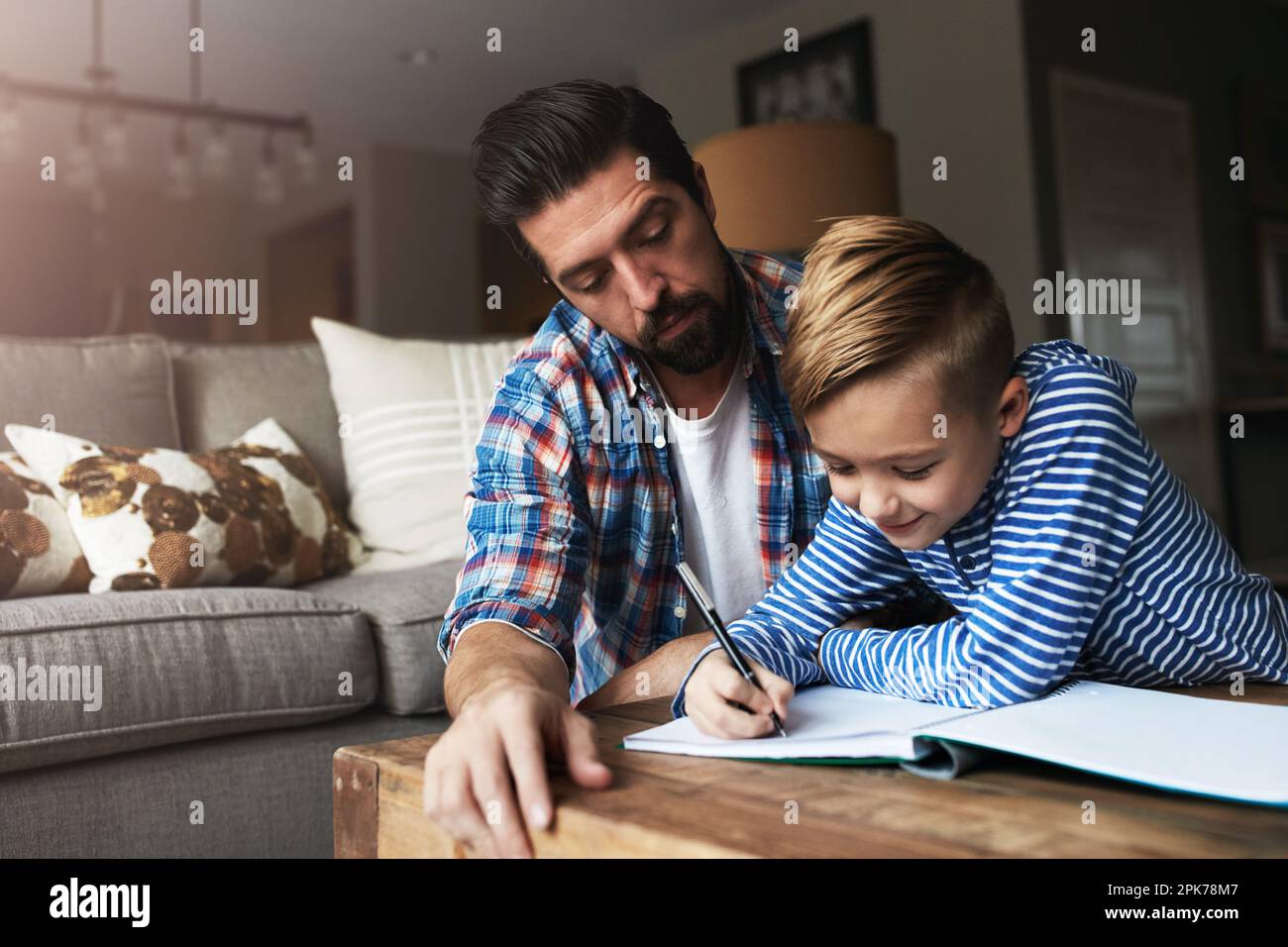 Its Dads duty to supervise. a father helping his little son with his ...