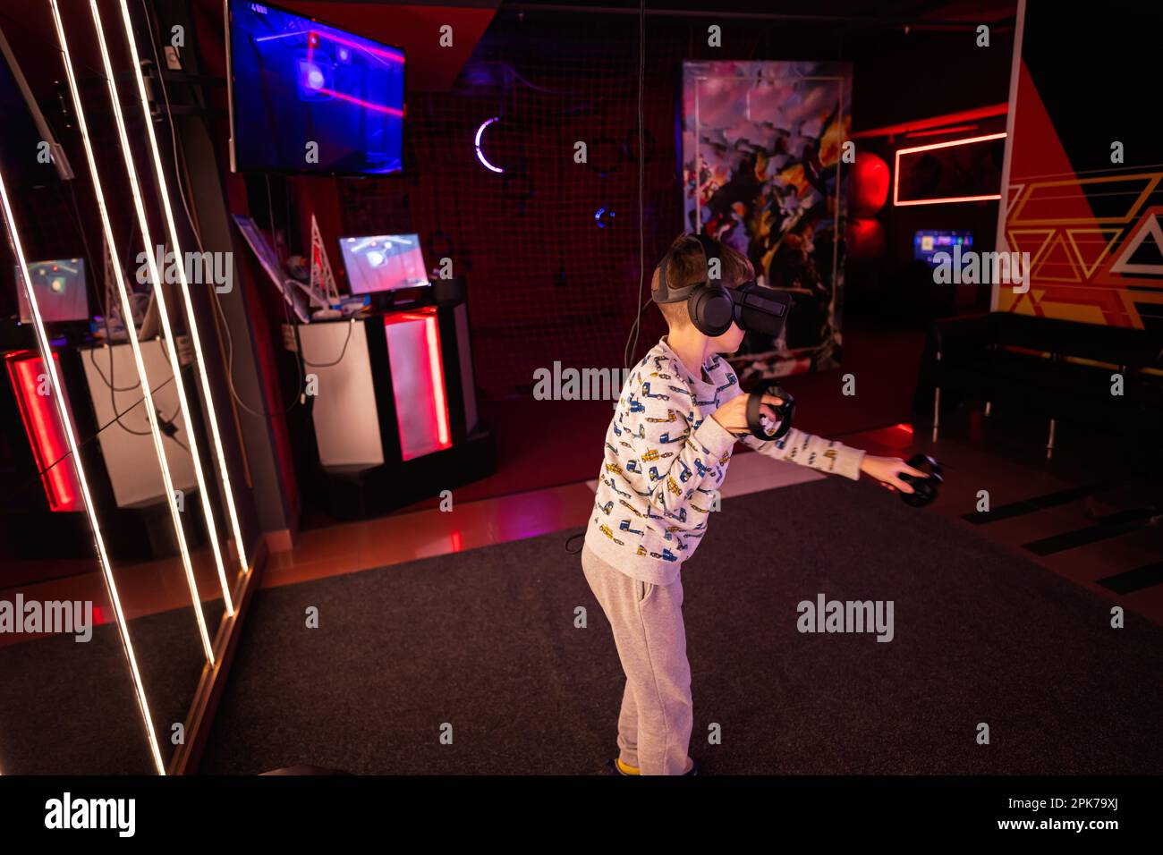Boy kid playing game using virtual reality headset and gamepads in ...
