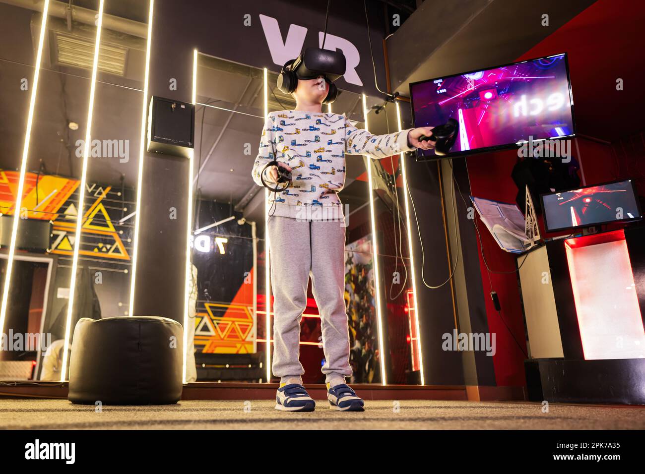 Boy kid playing game using virtual reality headset and gamepads in ...